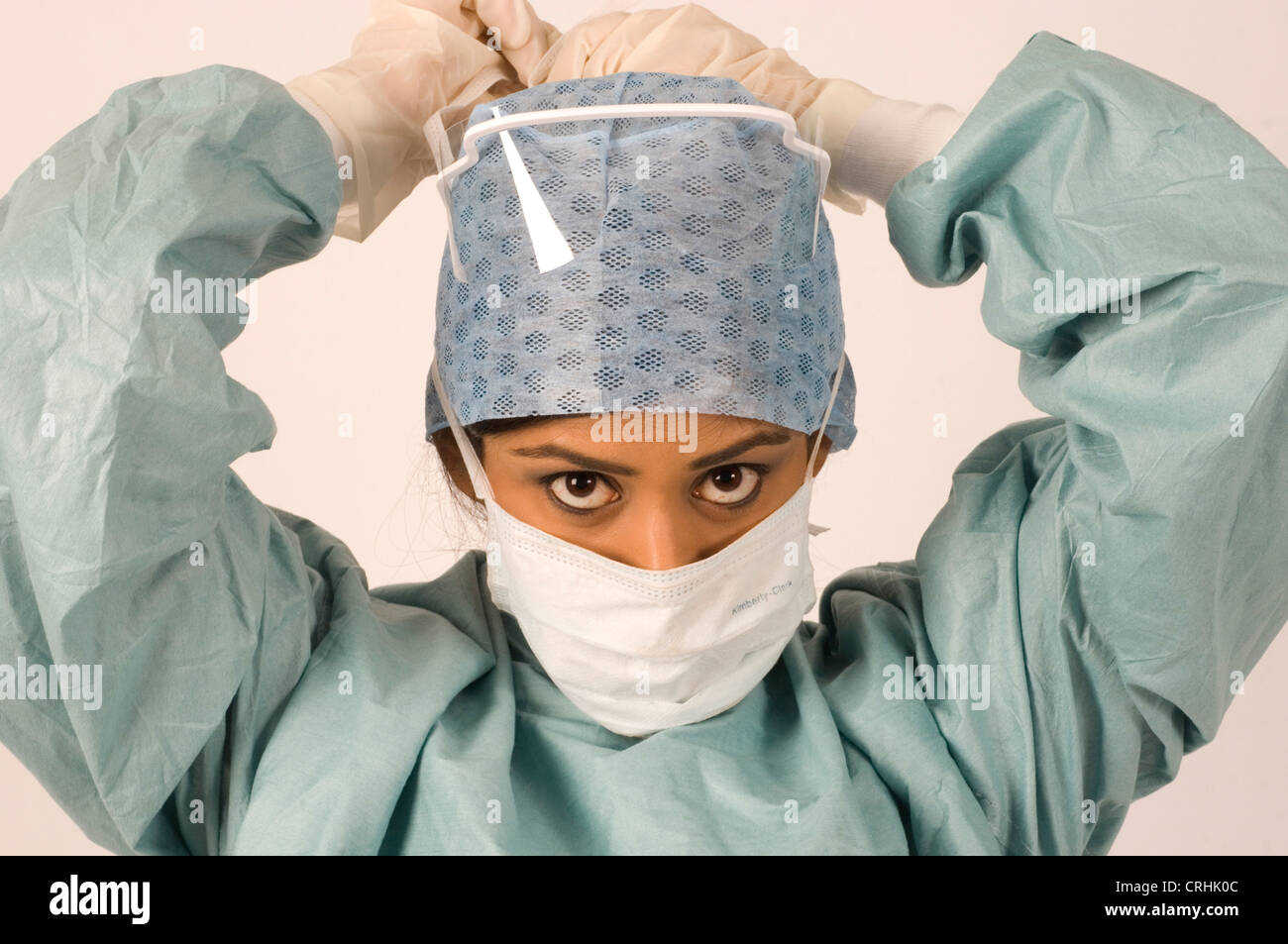 Female surgeon ties her surgical mask around her hi-res stock ...