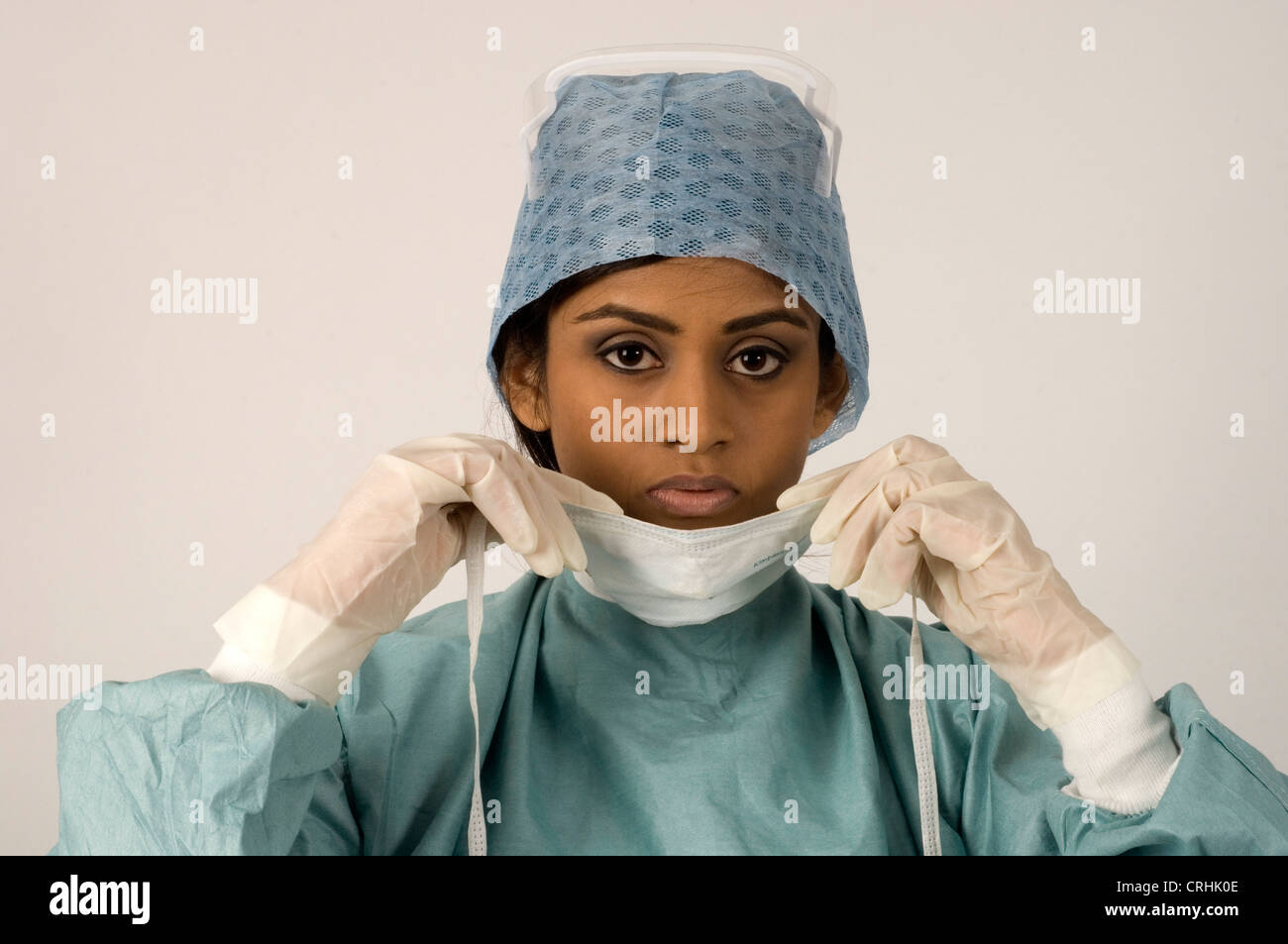 Female surgeon ties her surgical mask around her hi-res stock ...