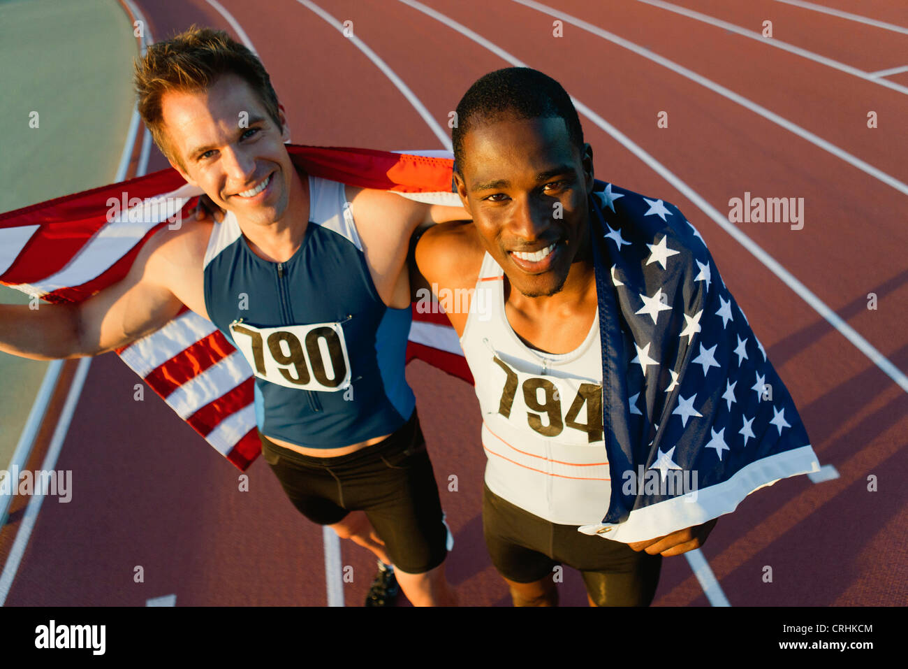 Running teammates holding up American flag after race Stock Photo - Alamy