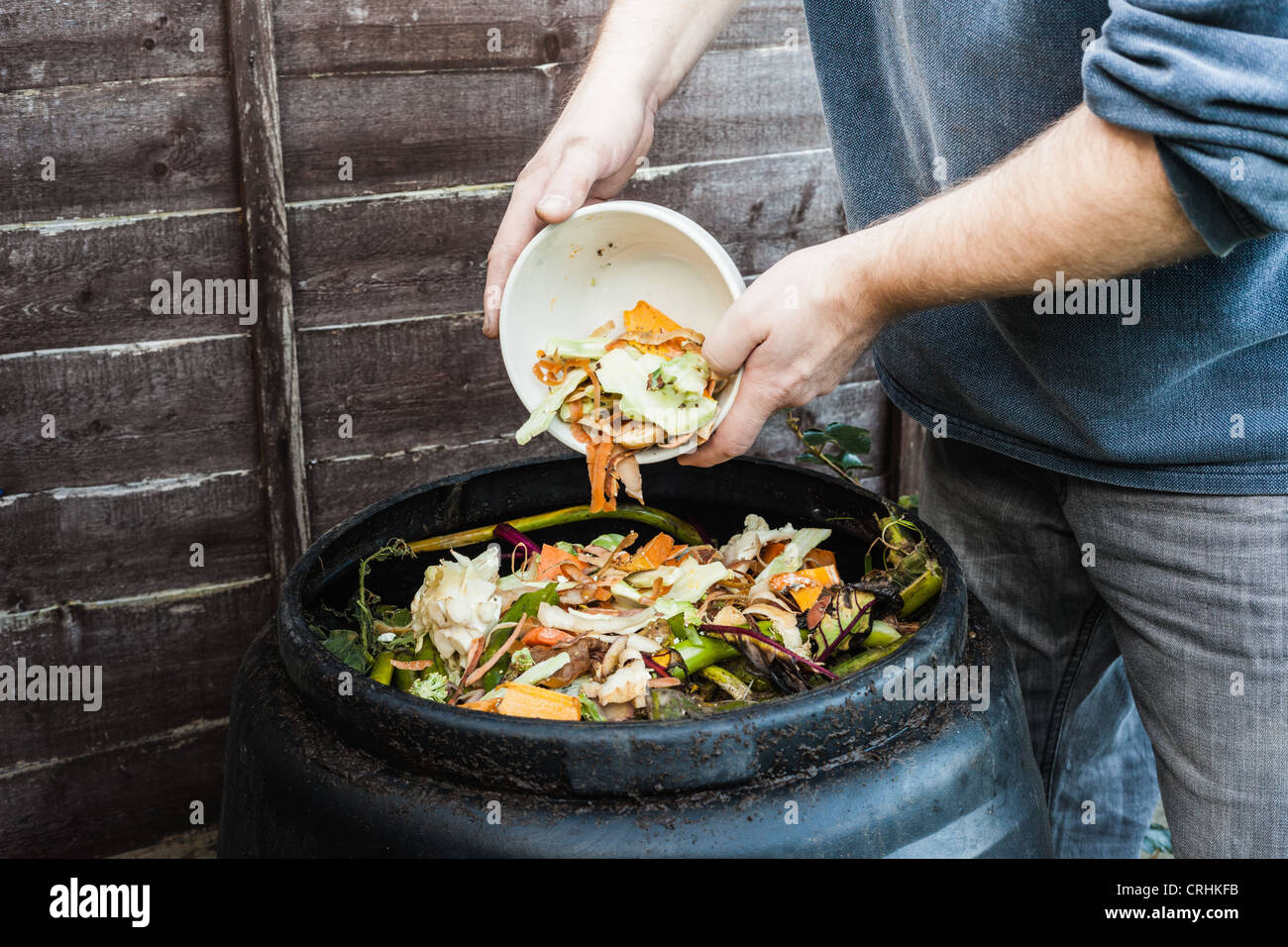 Man adding to compost bin outdoors Stock Photo - Alamy
