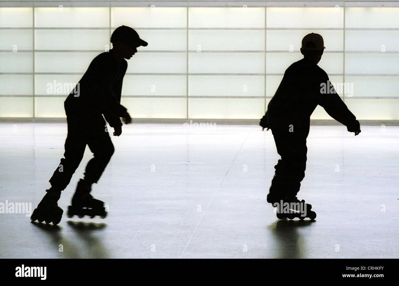 Silhouettes of two boys on inline skates Stock Photo - Alamy