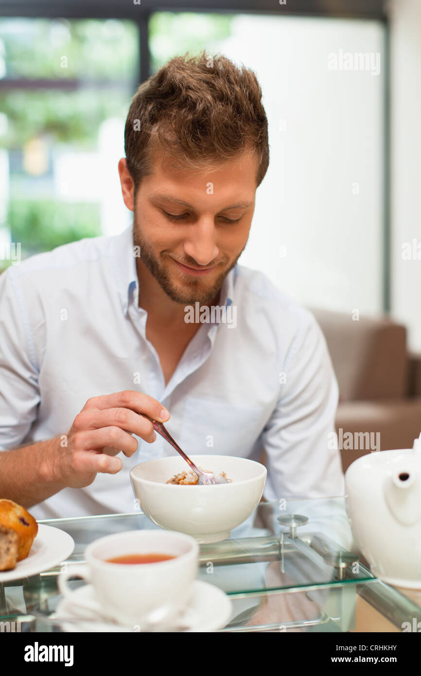 Smiling man eating breakfast at table Stock Photo - Alamy
