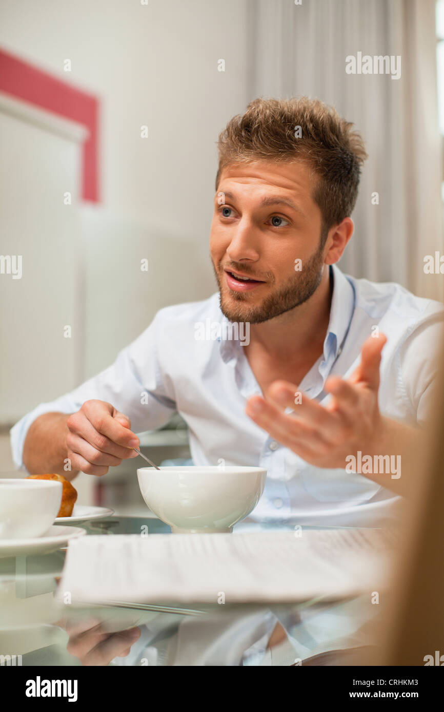 Smiling man talking at breakfast Stock Photo - Alamy