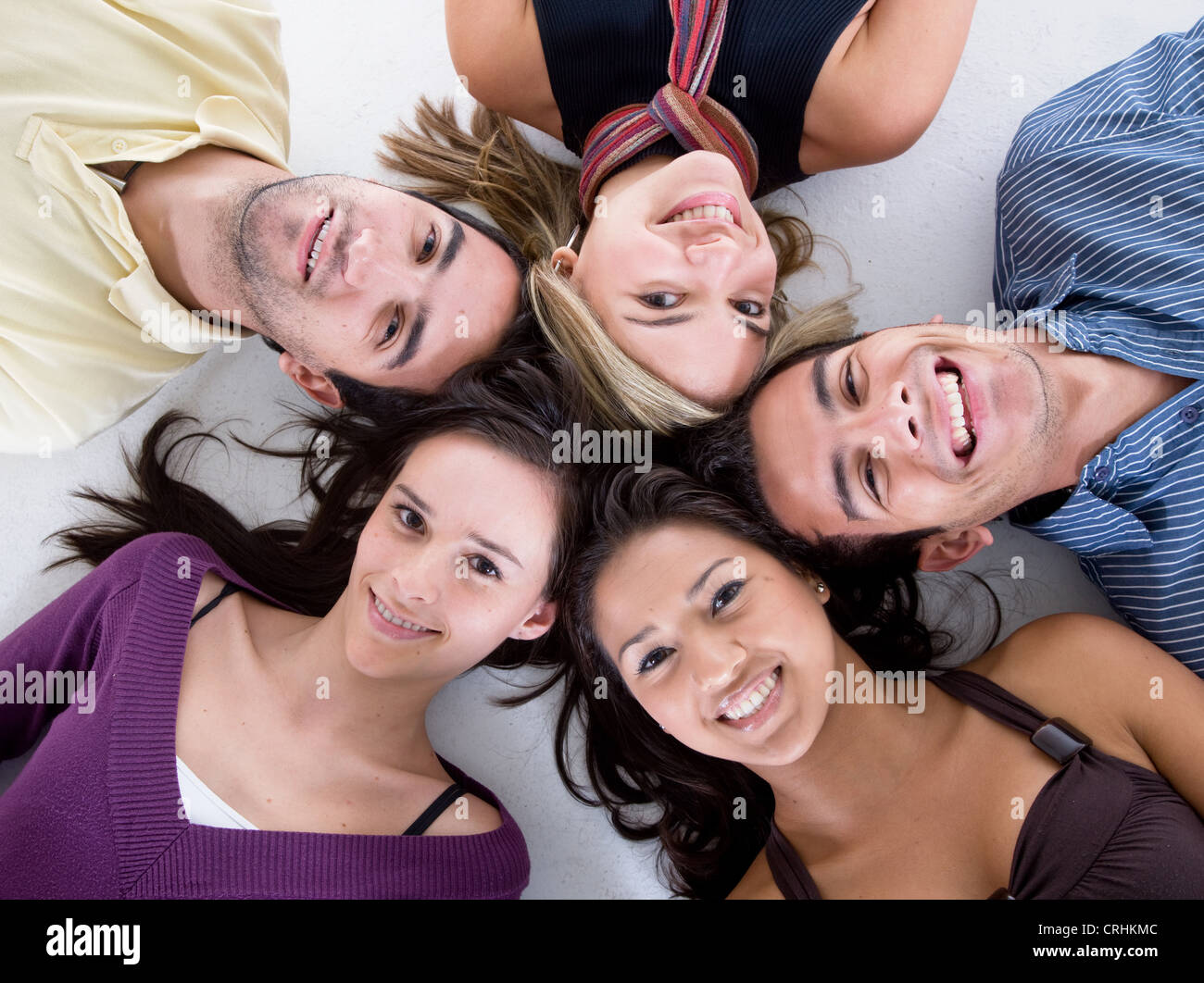 happy group of friends smiling with their heads together on the floor ...