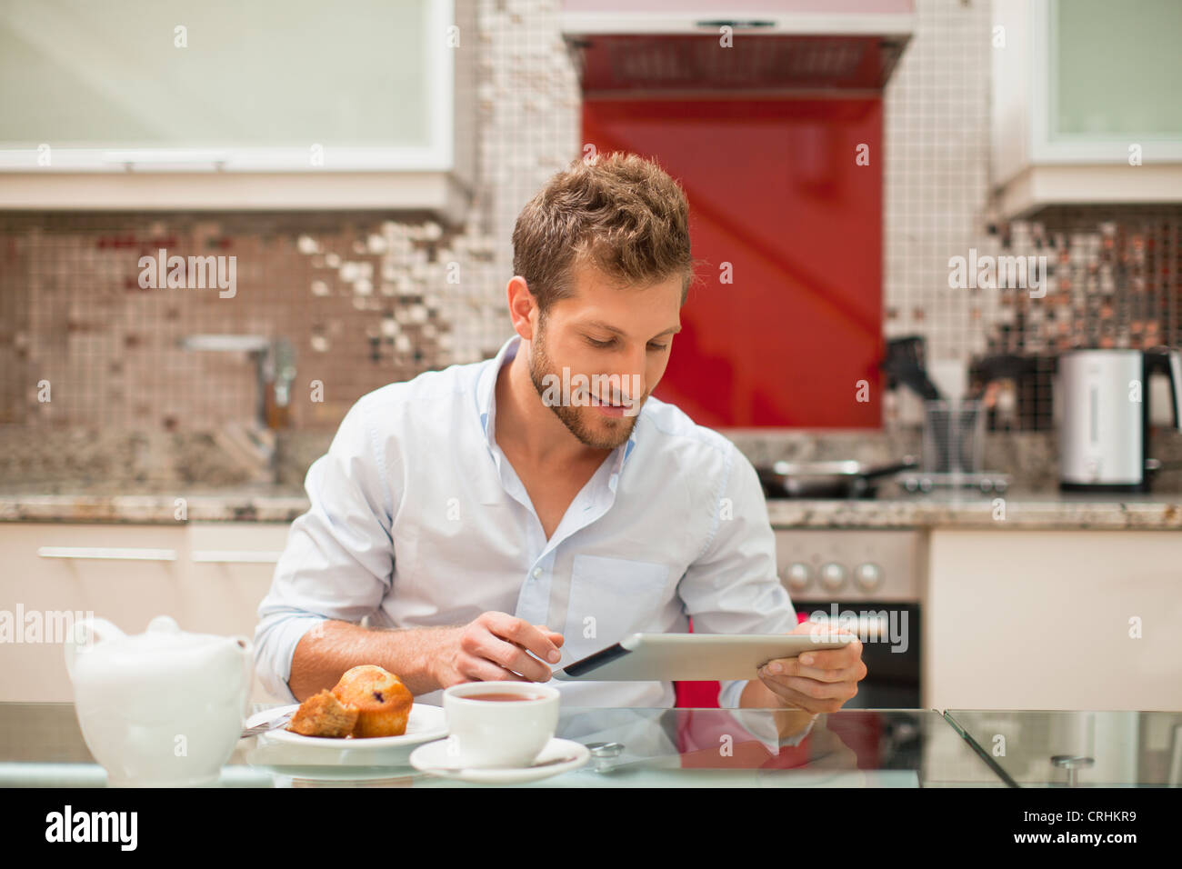 Smiling man reading at breakfast Stock Photo - Alamy