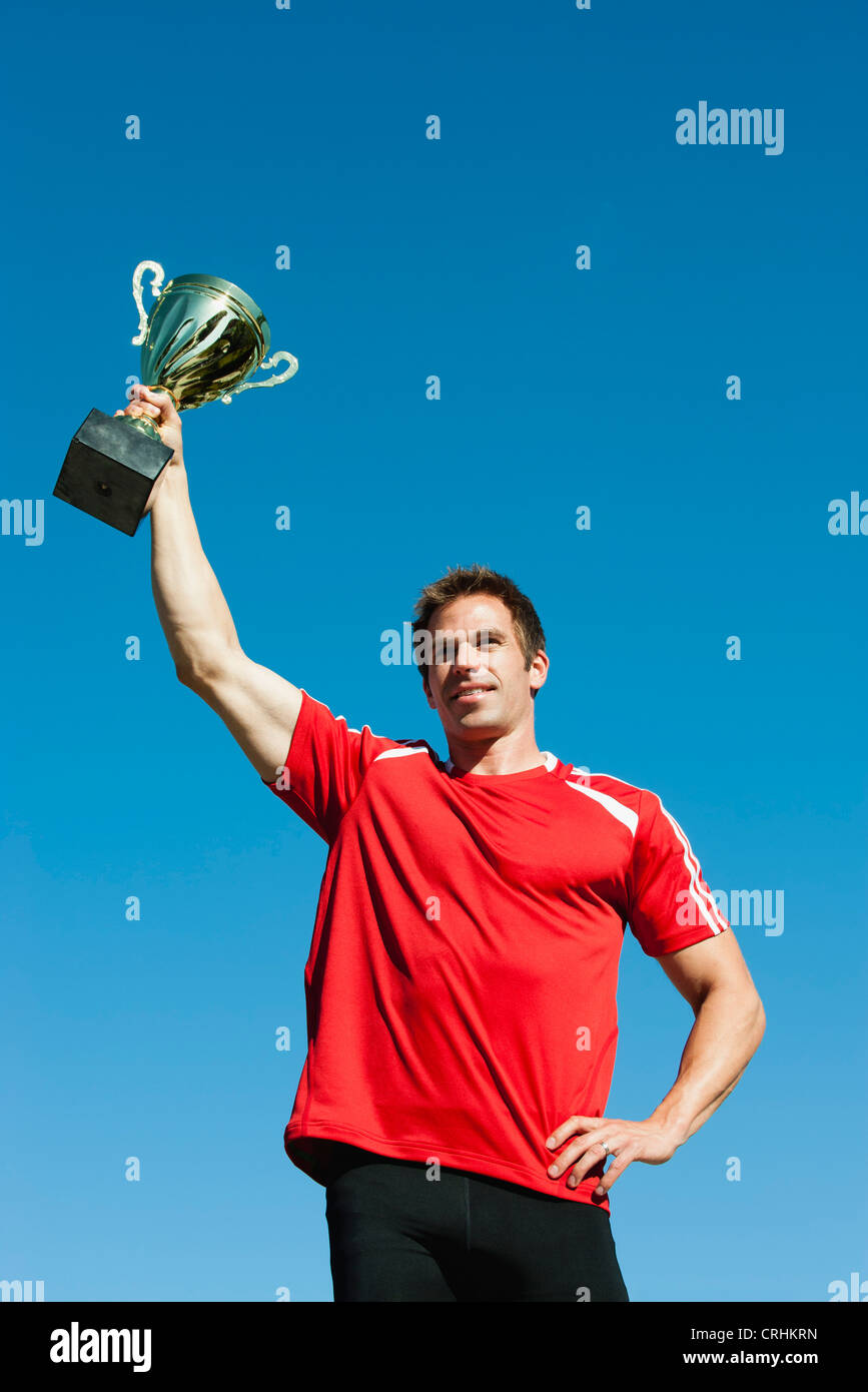 Athlete holding up trophy Stock Photo - Alamy