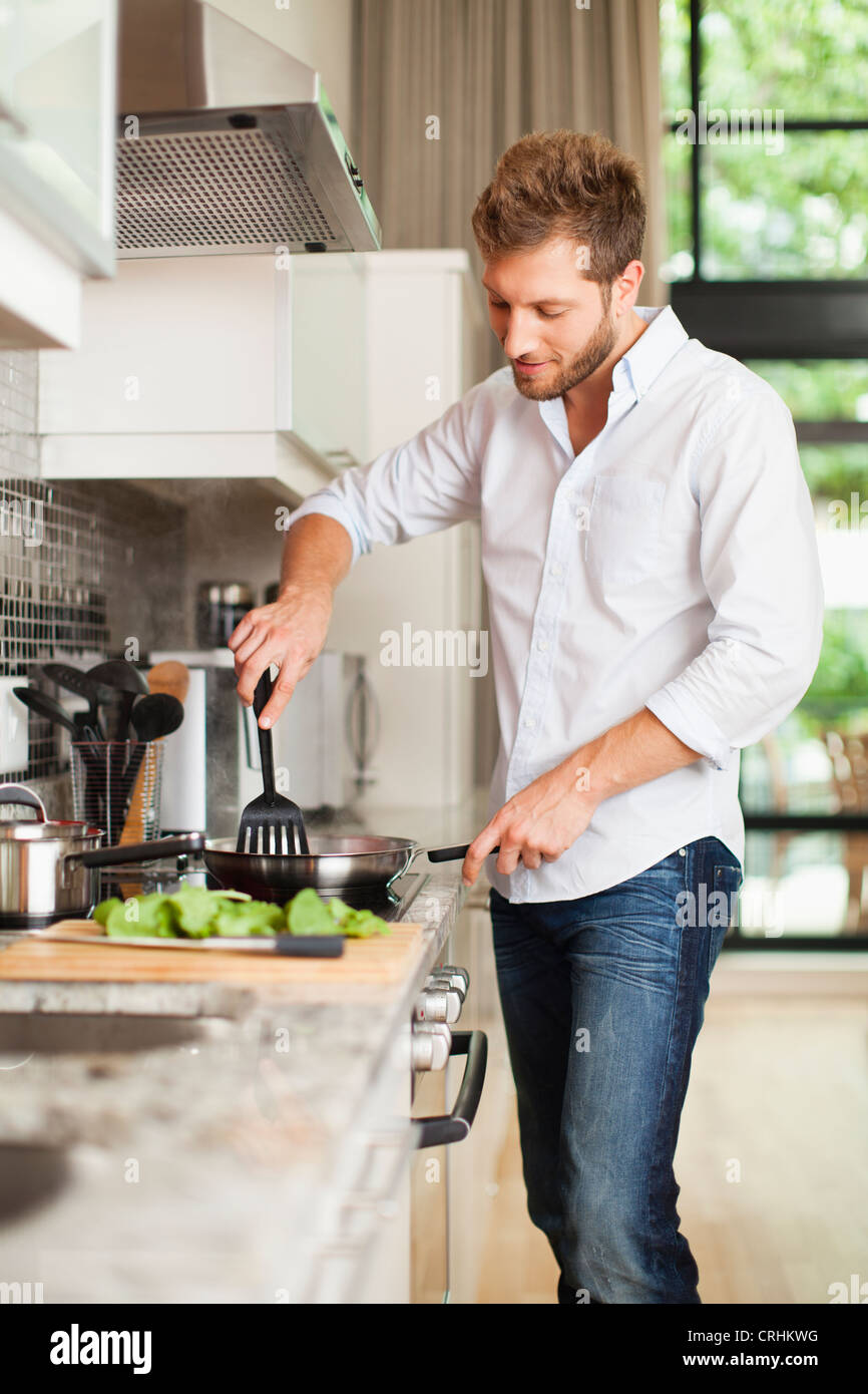 Smiling man cooking in kitchen Stock Photo - Alamy