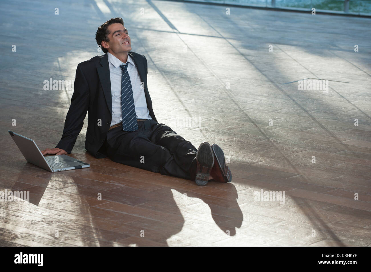 Businessman sits on a floor with the laptop in a lap Stock Photo - Alamy