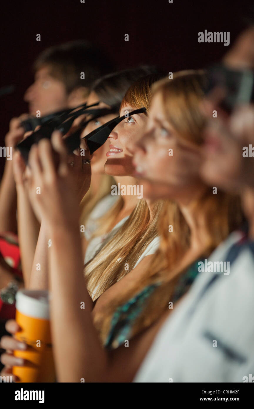 Audience in movie theater putting on 3-D glasses Stock Photo - Alamy