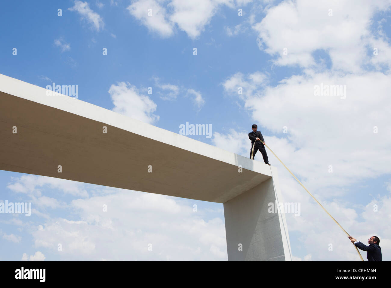 Businessman lending helping hand to colleague Stock Photo - Alamy