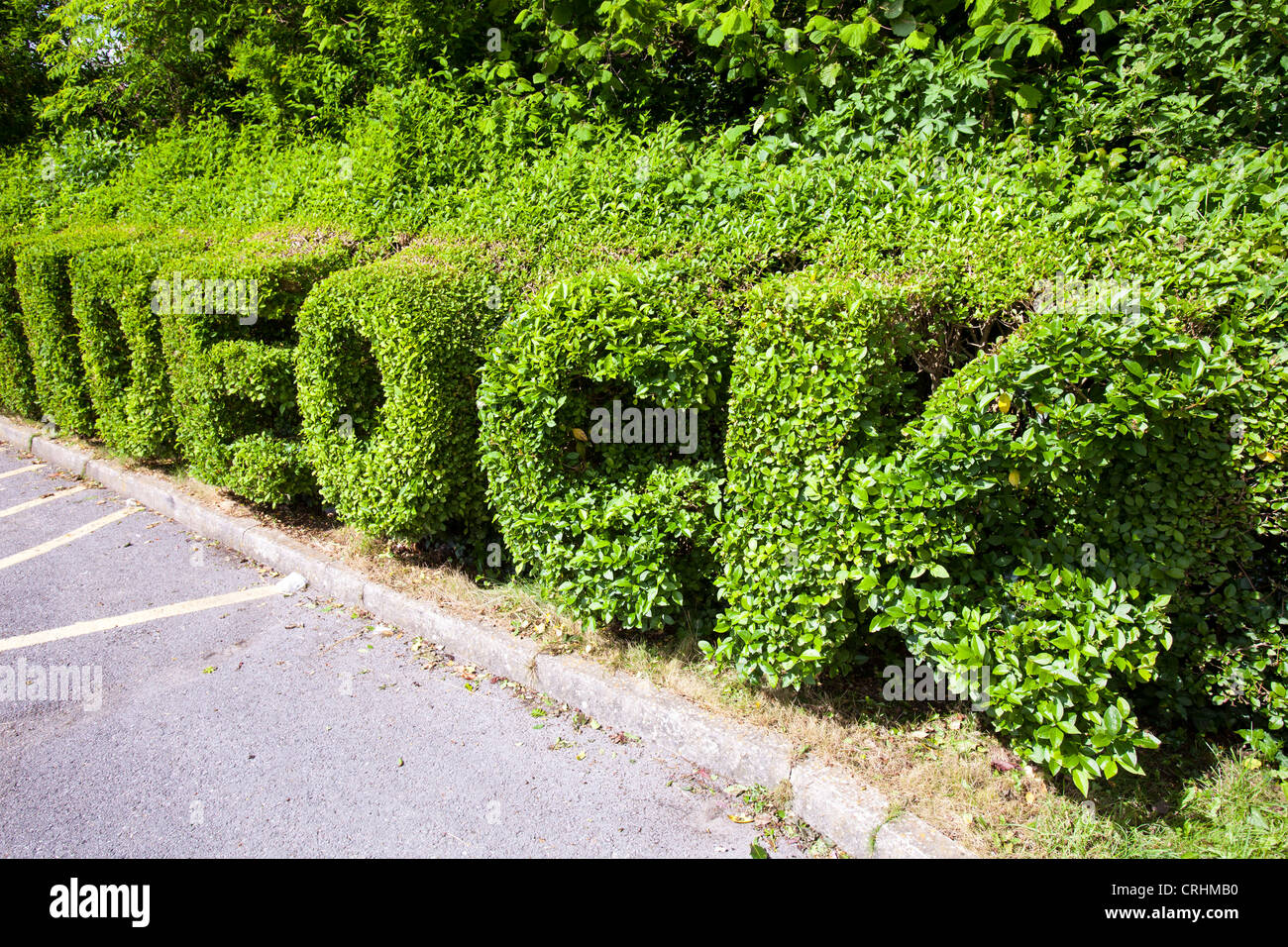 The village of Chideock in Dorset, with its name carved into a hedge ...