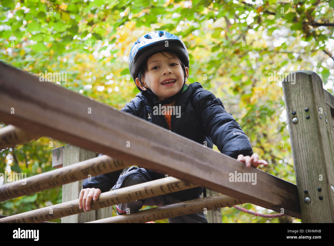 Boy playing on jungle gym Stock Photo - Alamy
