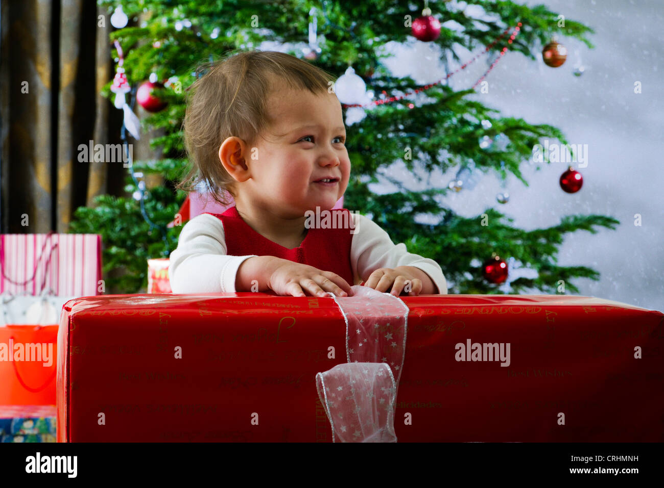 Happy girl unwrapping christmas gift hi-res stock photography and ...