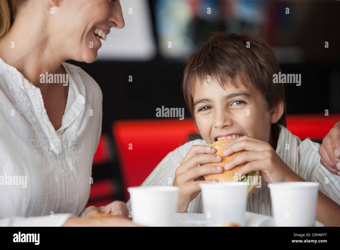 Boy eating hamburger in fast food restaurant Stock Photo - Alamy
