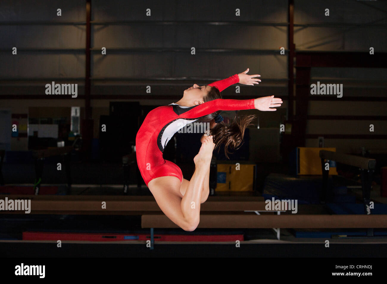 Gymnast jumping in air, bending backwards Stock Photo - Alamy