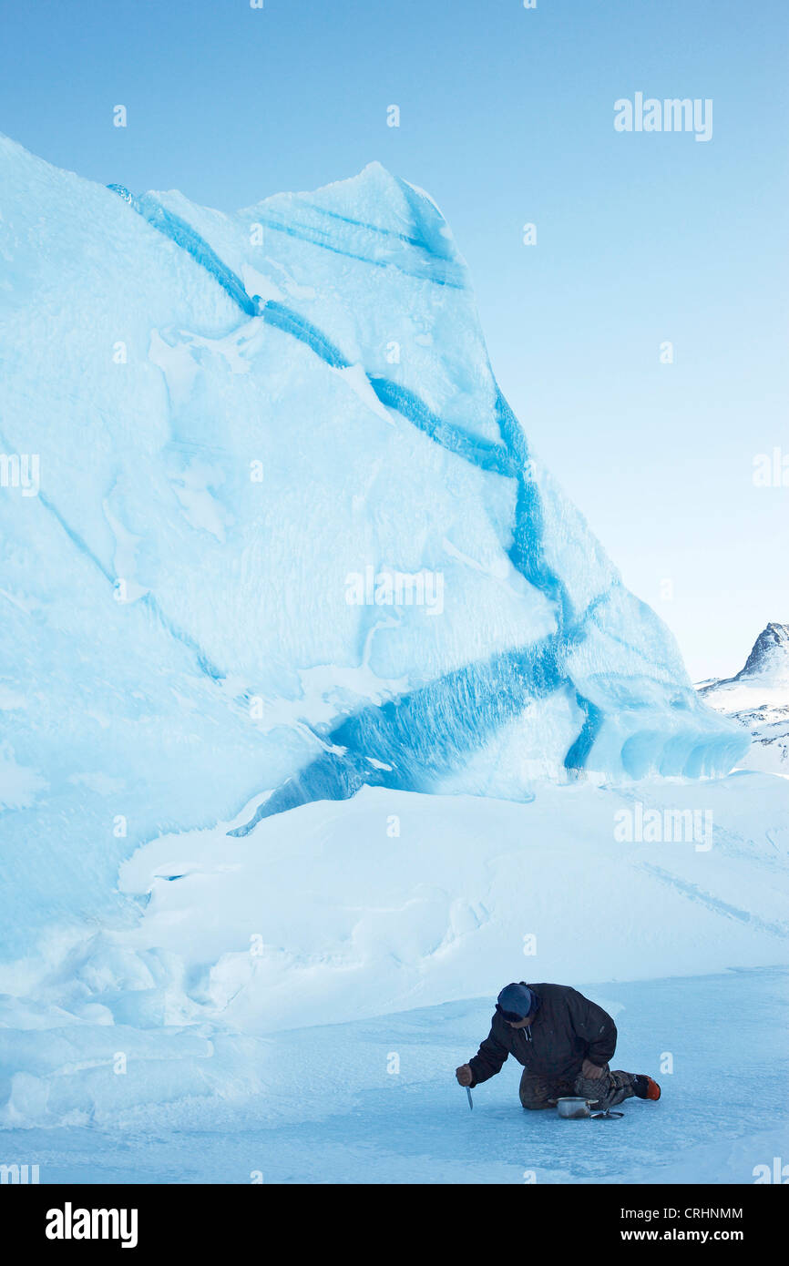 young inuit picking ice for drinking water abstraction, Greenland ...