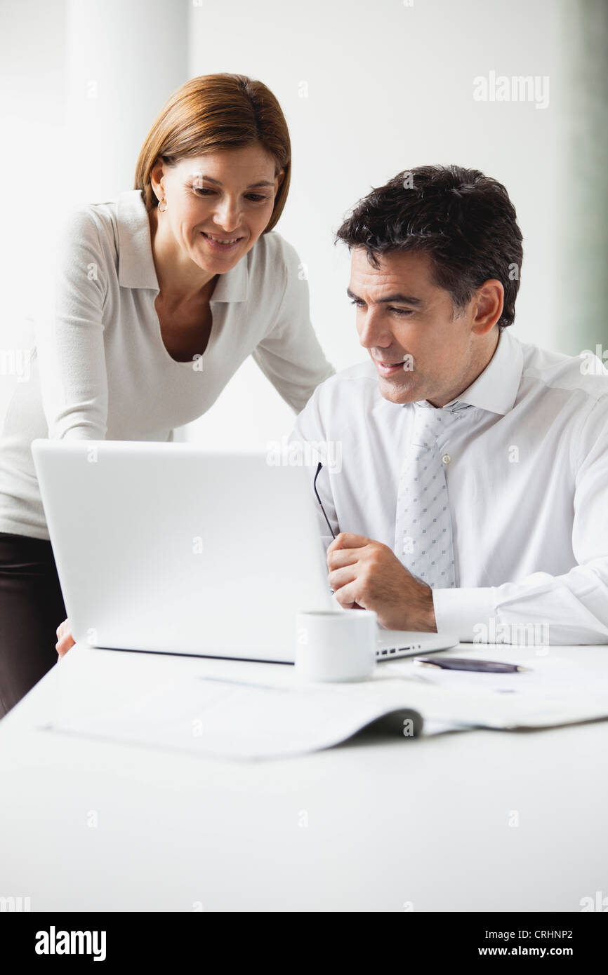 Business colleagues looking at laptop computer together Stock Photo - Alamy