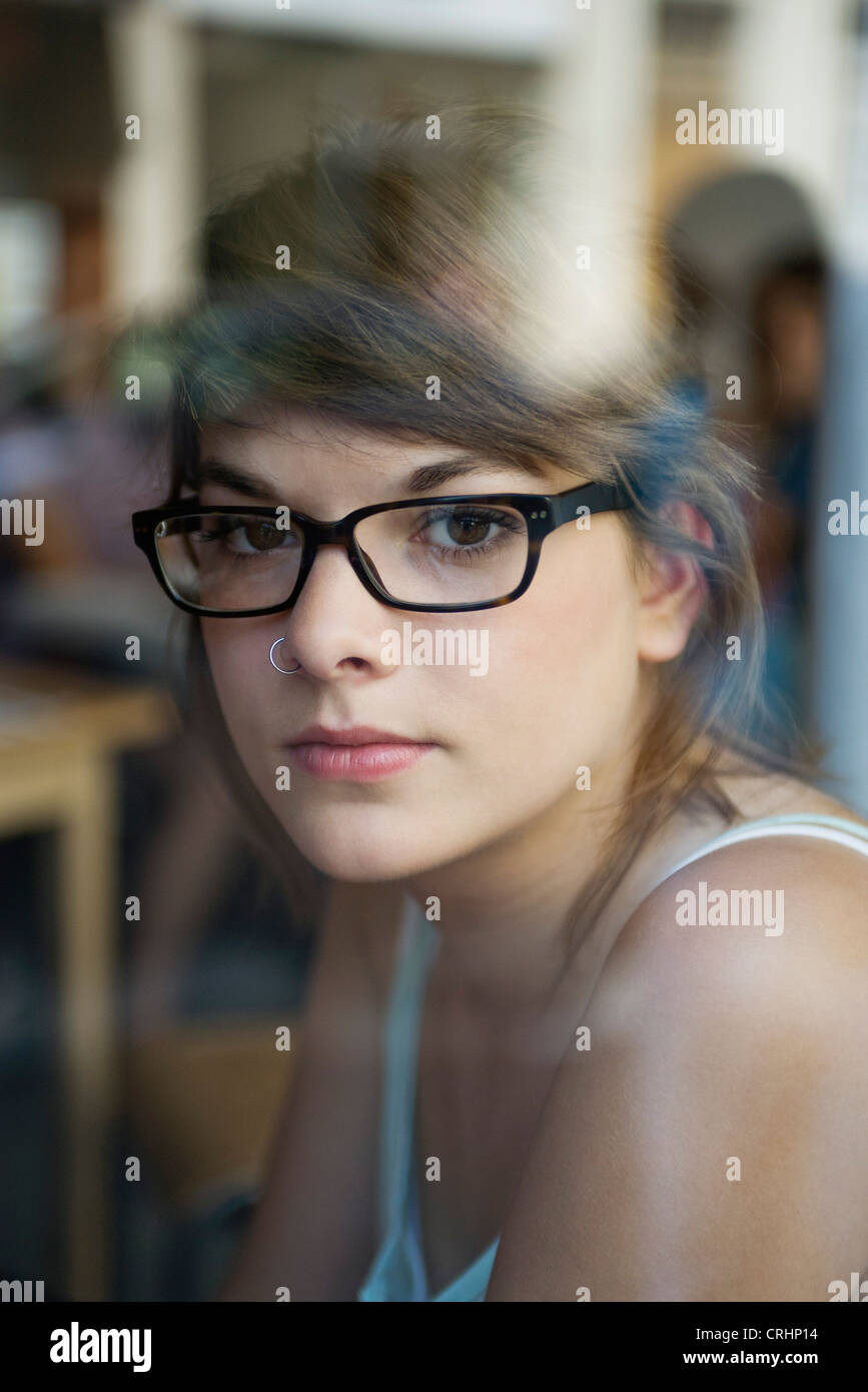 Young woman looking through window, portrait Stock Photo - Alamy