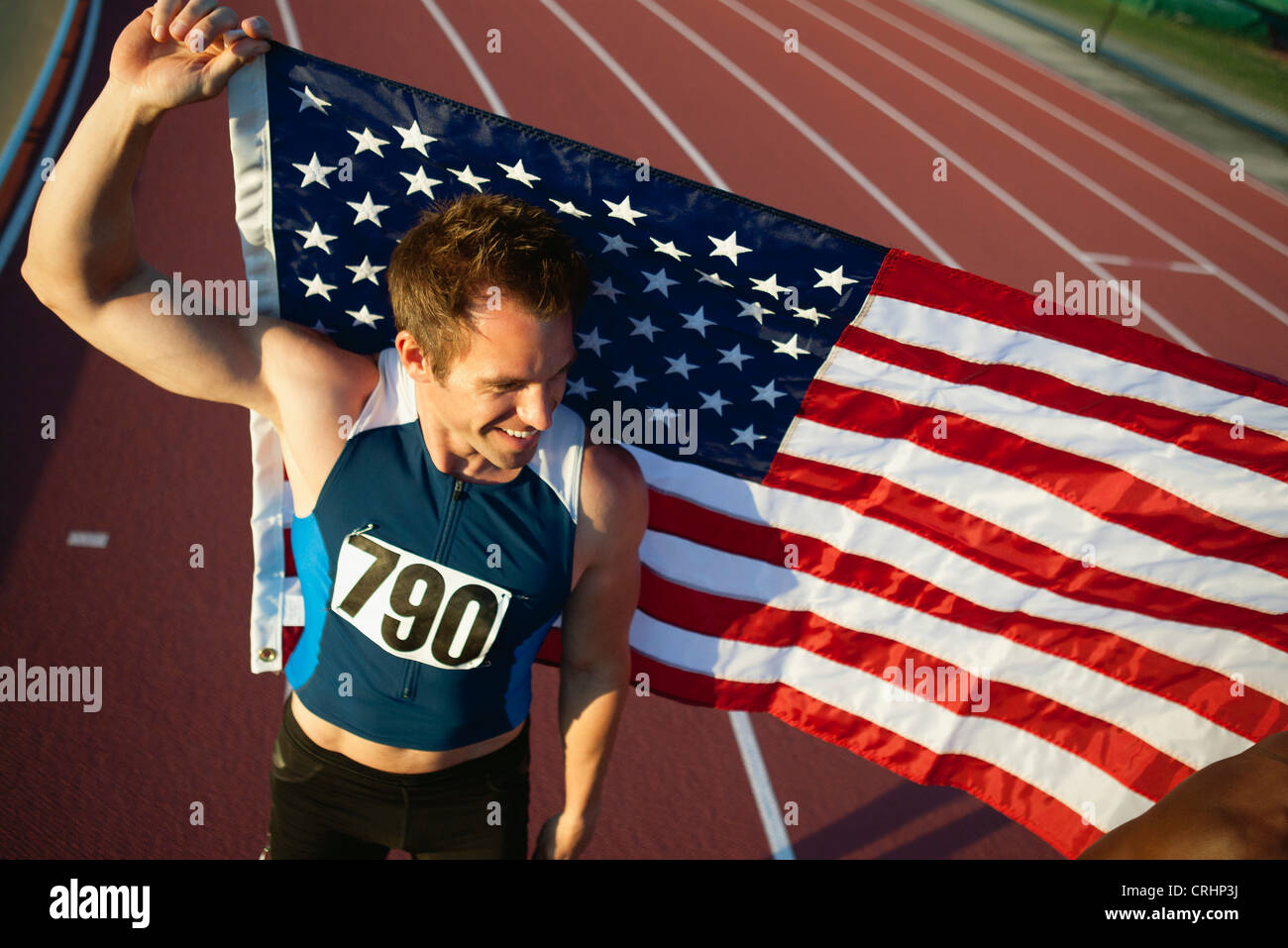 Runner holding up American flag after race Stock Photo - Alamy