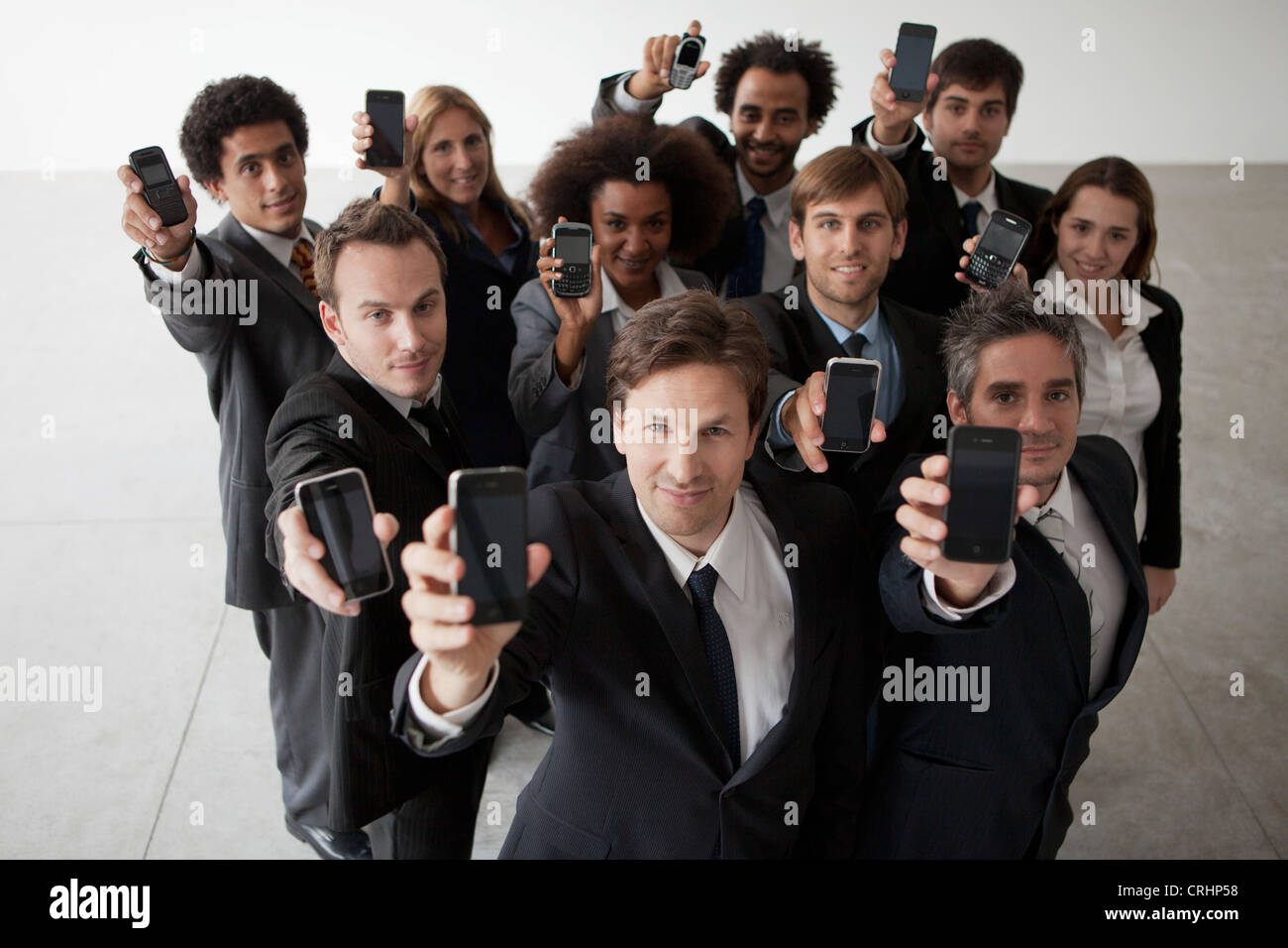 Business professionals holding aloft their cell phones Stock Photo - Alamy