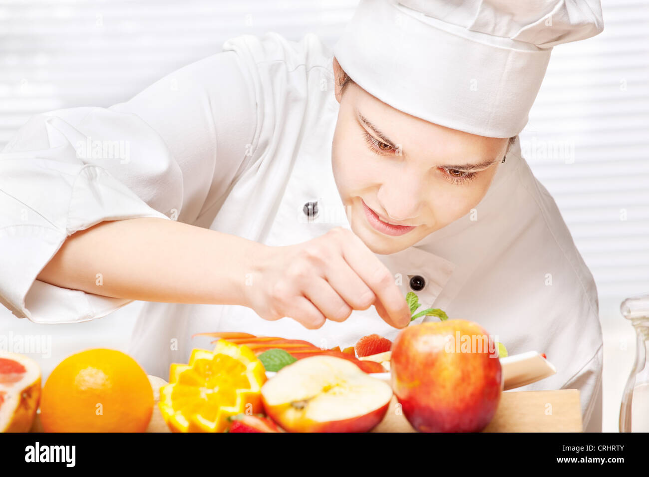 pretty young chef decorating delicious fruit plate Stock Photo - Alamy