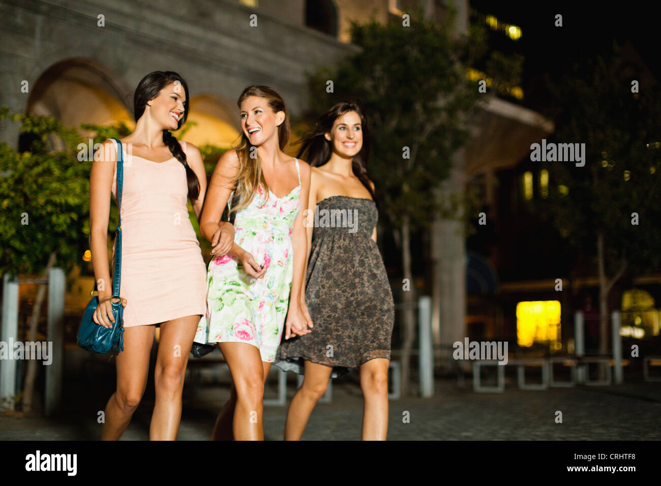 Women walking on city street at night Stock Photo - Alamy