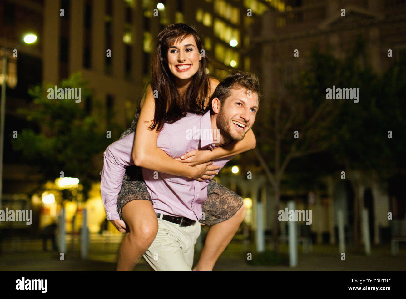 Man carrying girlfriend on city street Stock Photo - Alamy