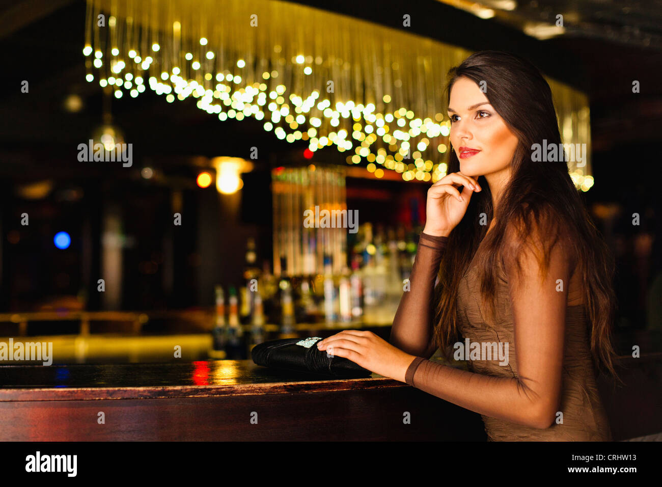 Smiling woman standing at bar Stock Photo - Alamy