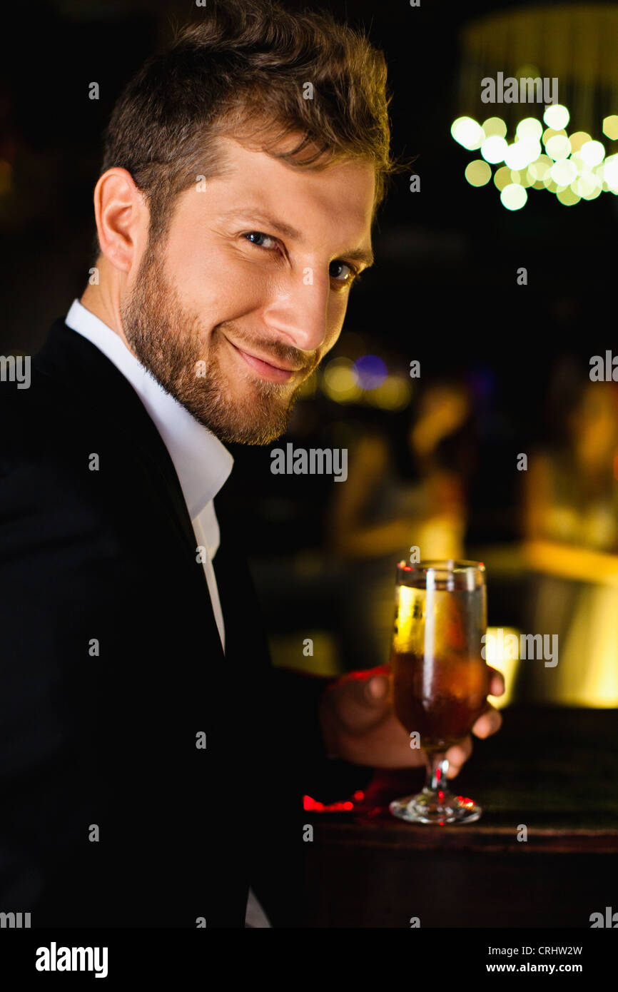 Smiling man having drink at bar Stock Photo - Alamy