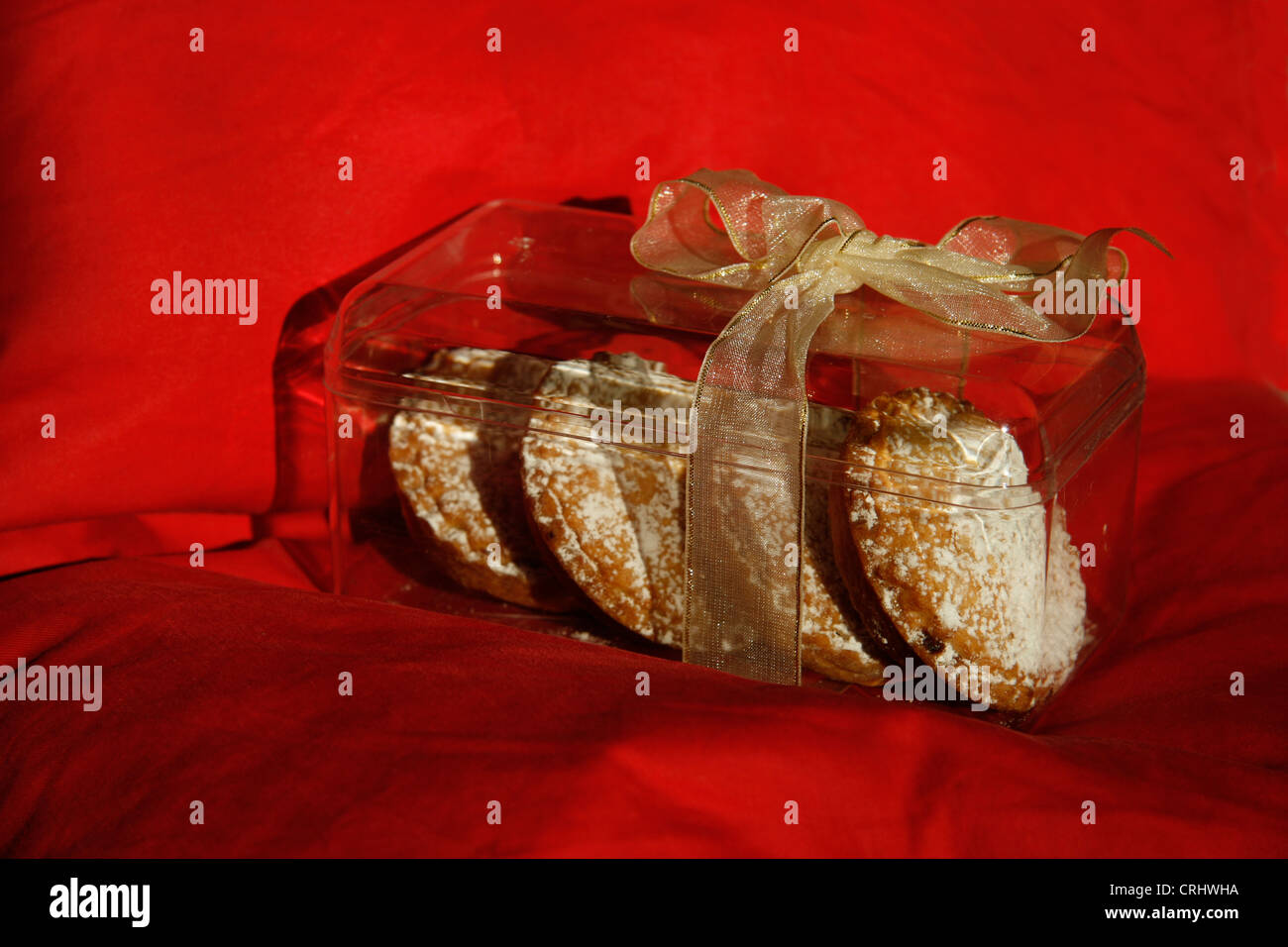 Transparent box of minced pies wrapped in ribbon on red cusion Stock ...