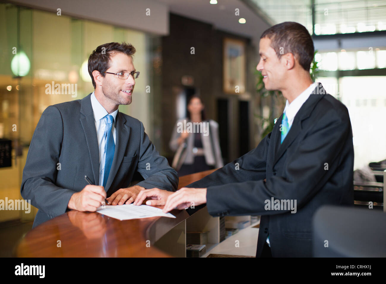 Businessman checking into hotel Stock Photo - Alamy