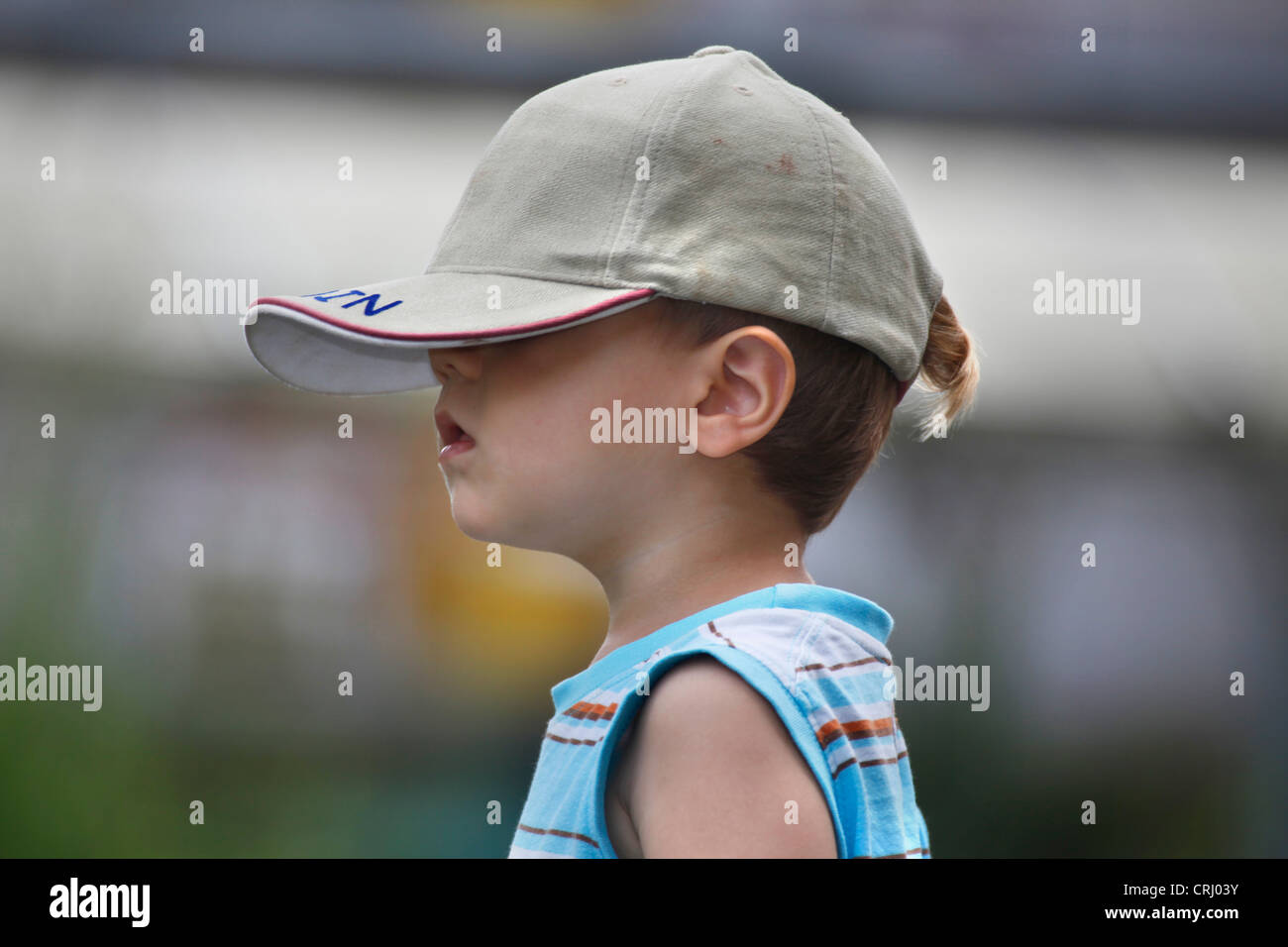 little boy with to large peaked cap doesn't see anything Stock Photo ...