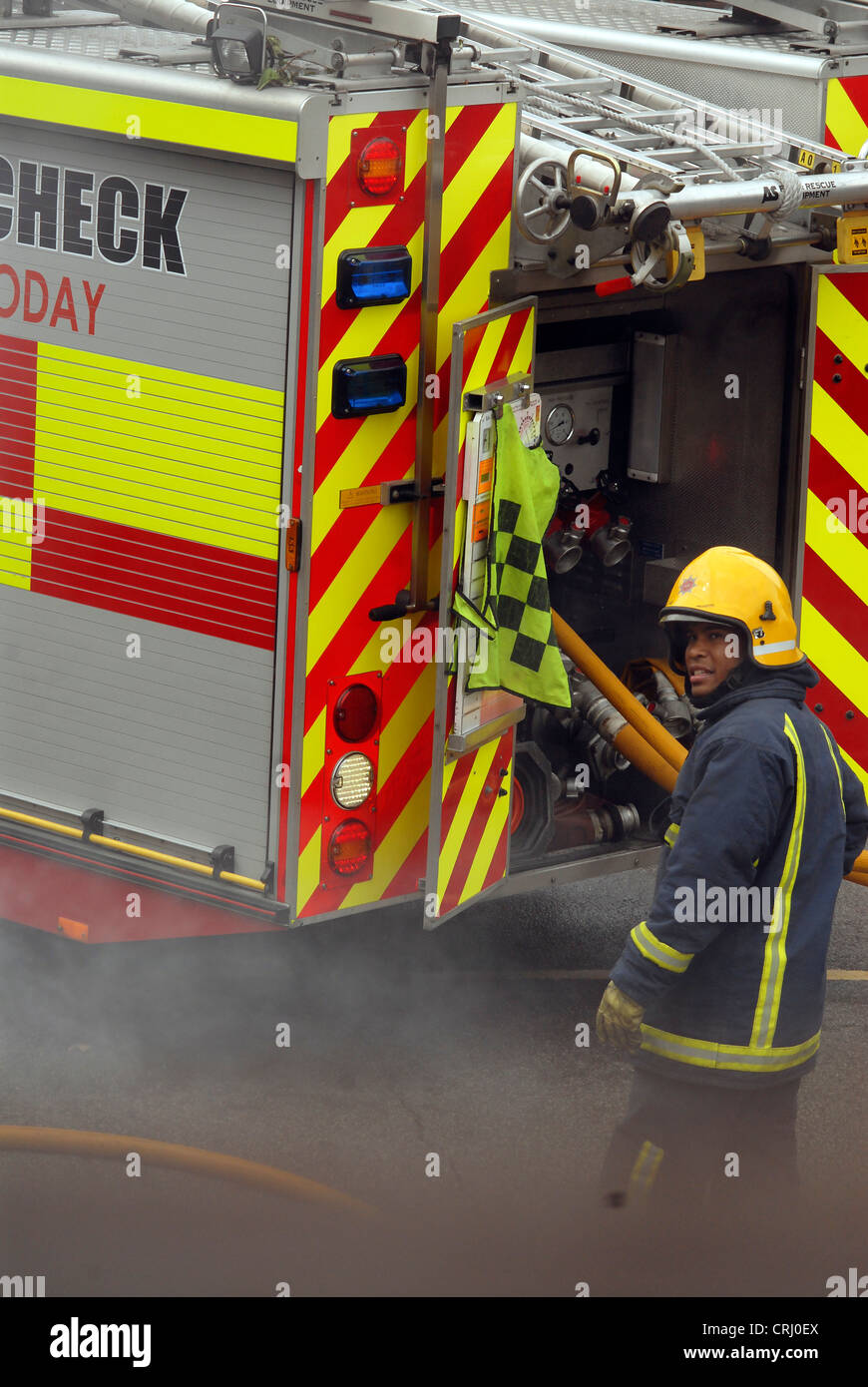 A fire fighter waits behind a fire truck Stock Photo - Alamy