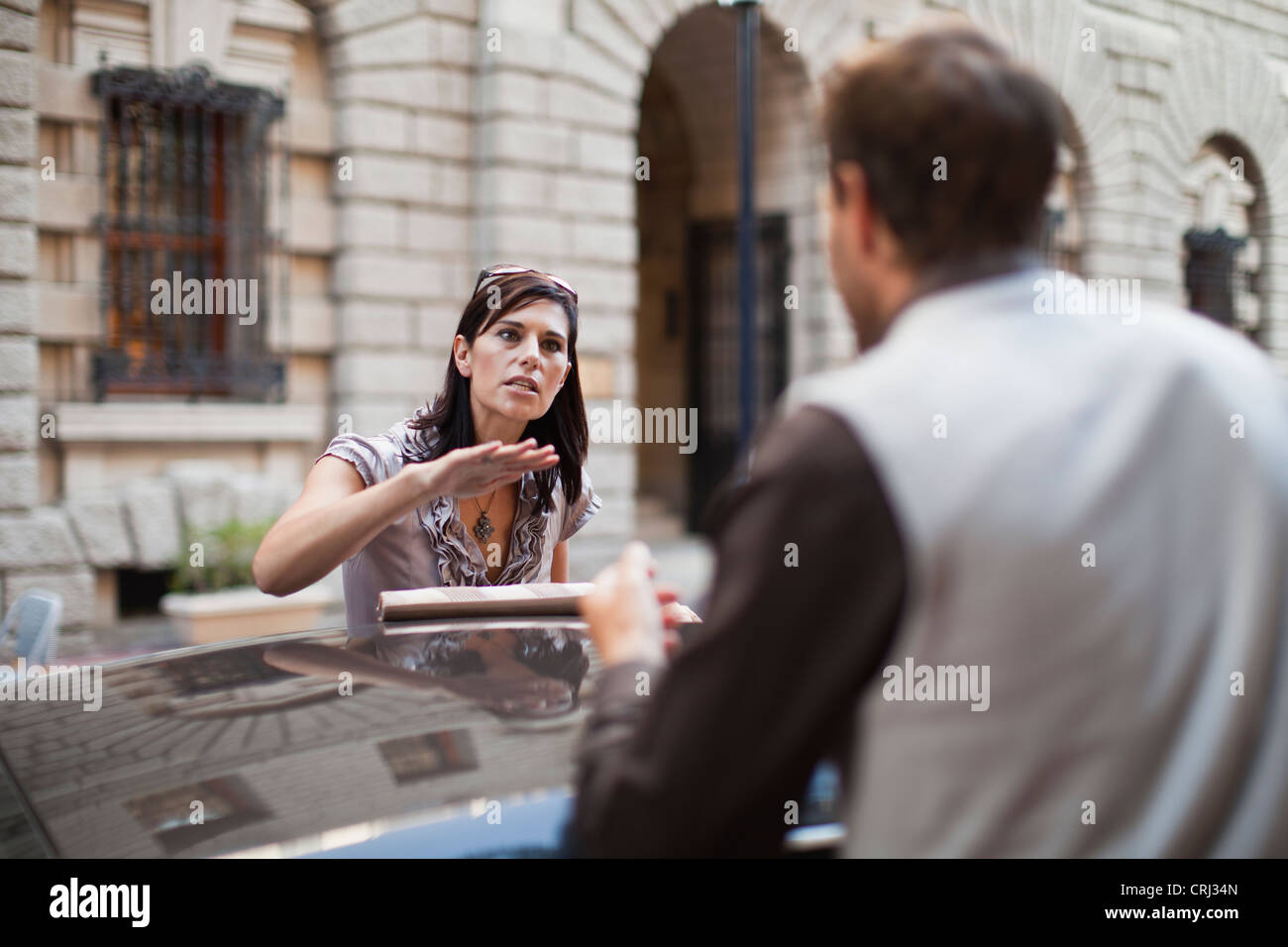 Couple arguing over sports car Stock Photo - Alamy