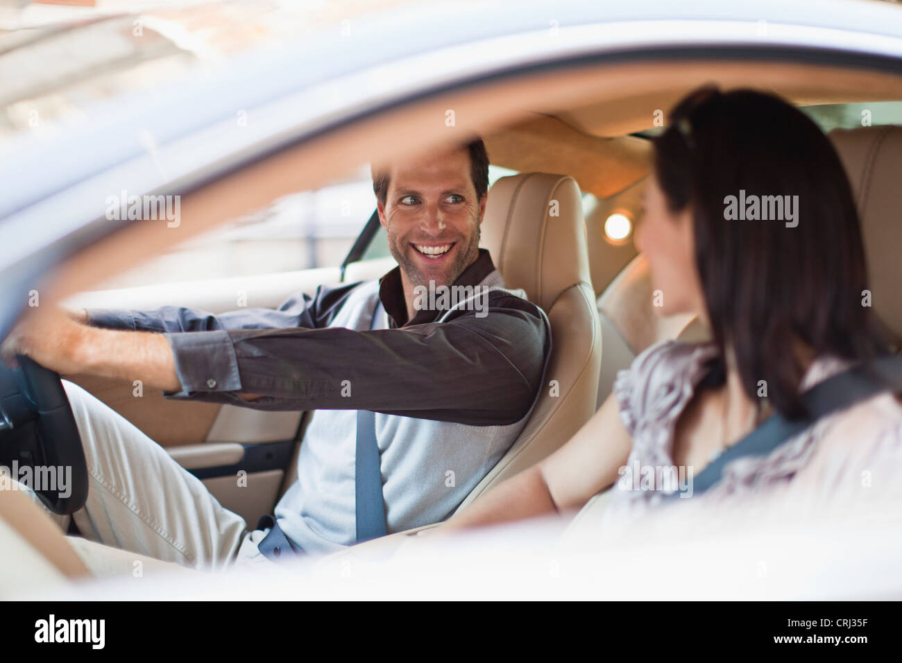 Smiling couple talking in sports car Stock Photo - Alamy