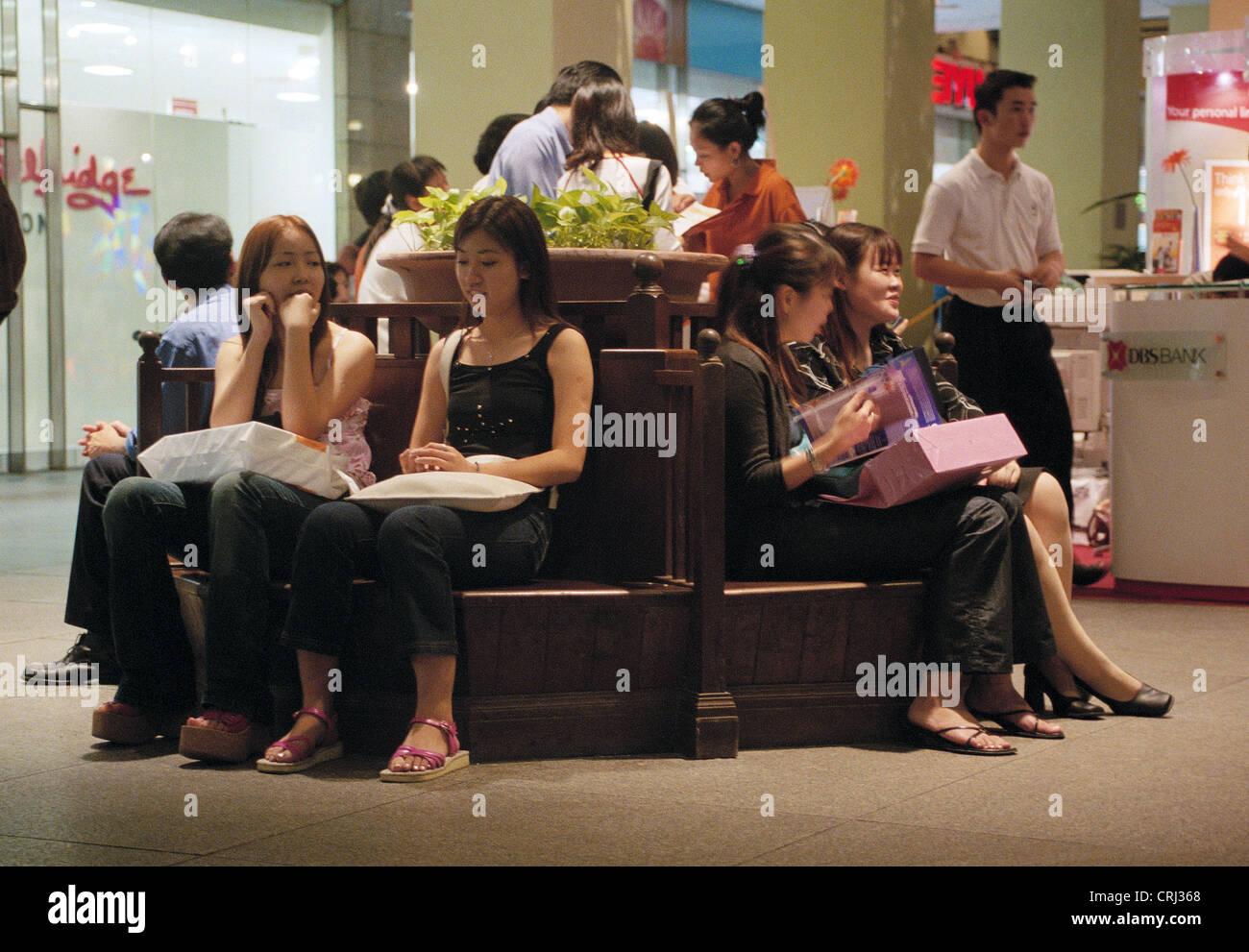 Young women could sit on a bench in a shopping mall in Singapore Stock ...