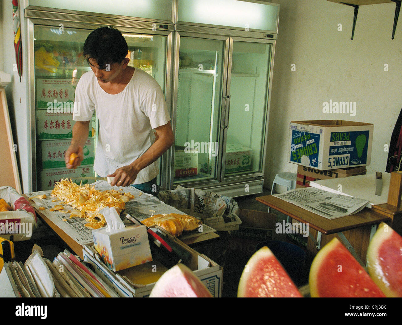 A young man in a small fruit shop in Singapore Stock Photo - Alamy