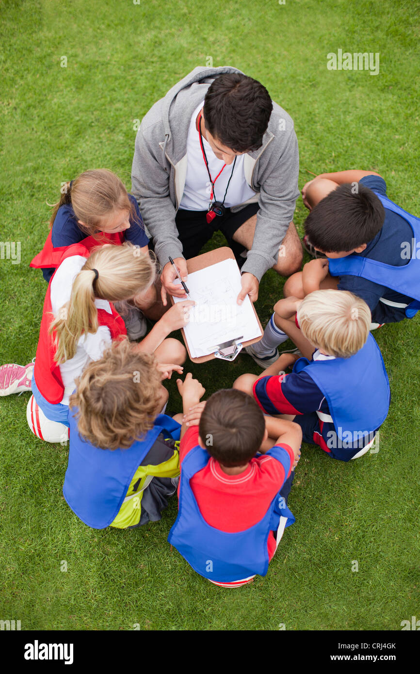 Coach talking to childrens soccer team Stock Photo - Alamy