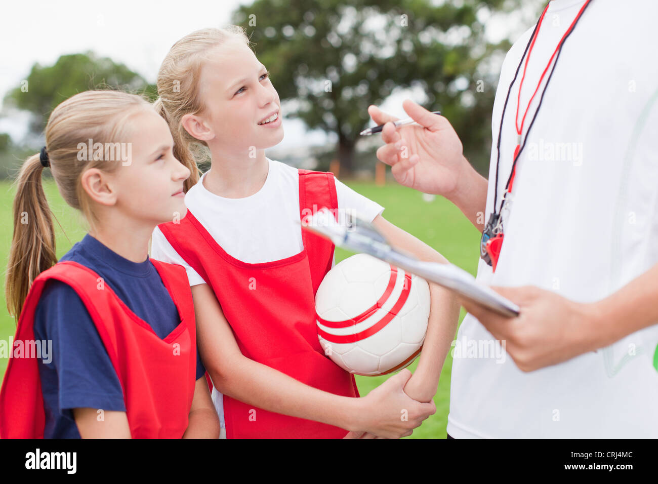Coach talking to children on soccer team Stock Photo - Alamy
