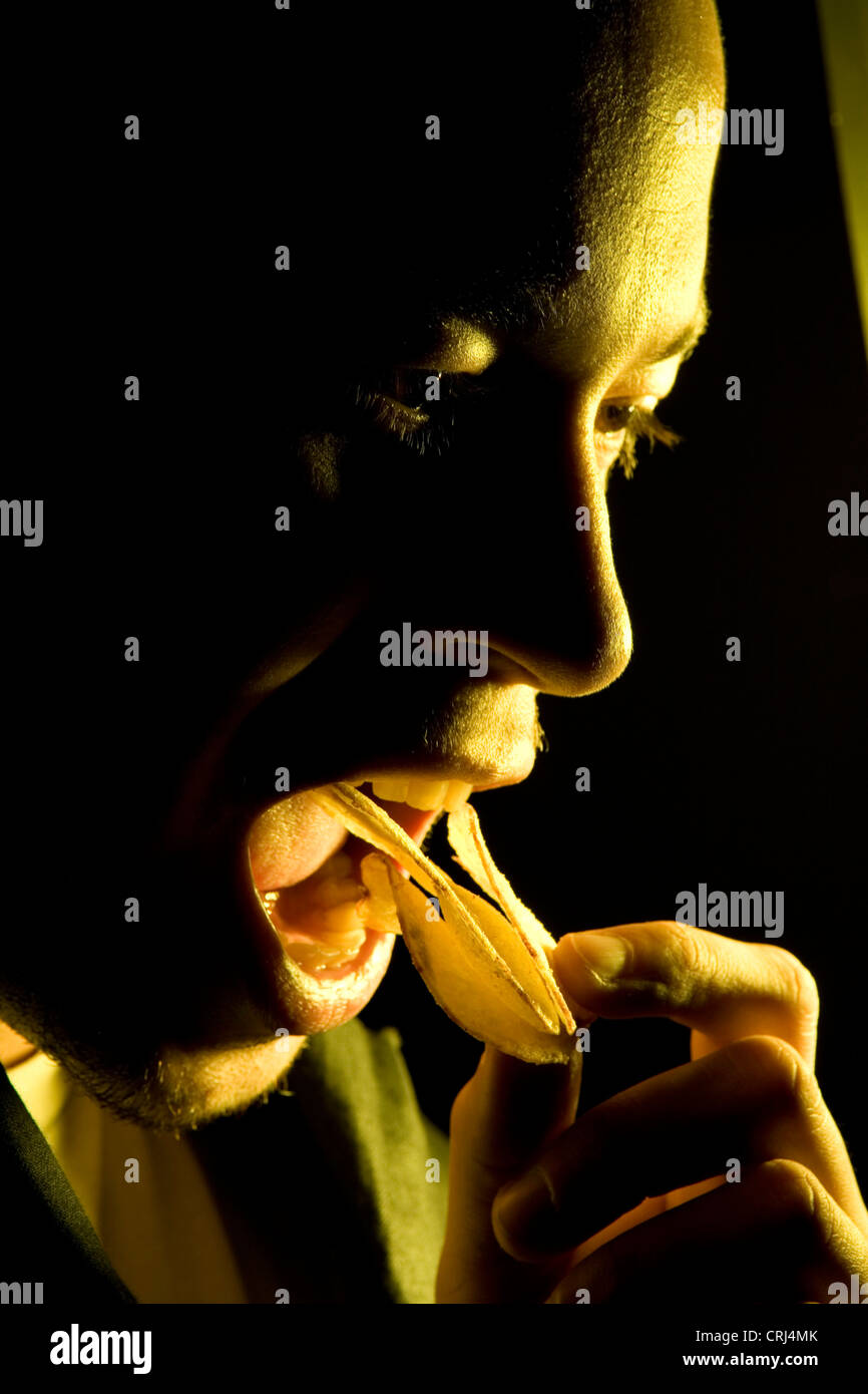 Profile of a young man eating crisps Stock Photo - Alamy