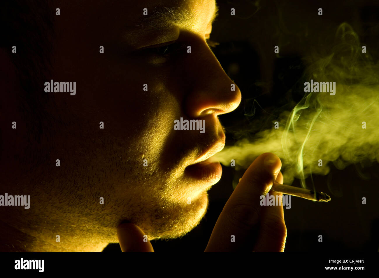 A young male smoking a cannabis joint Stock Photo - Alamy