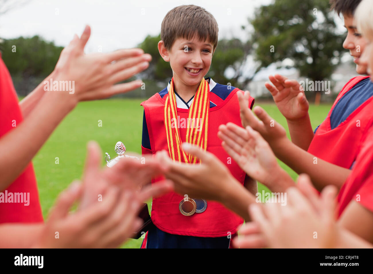 Children cheering teammate with trophy Stock Photo - Alamy