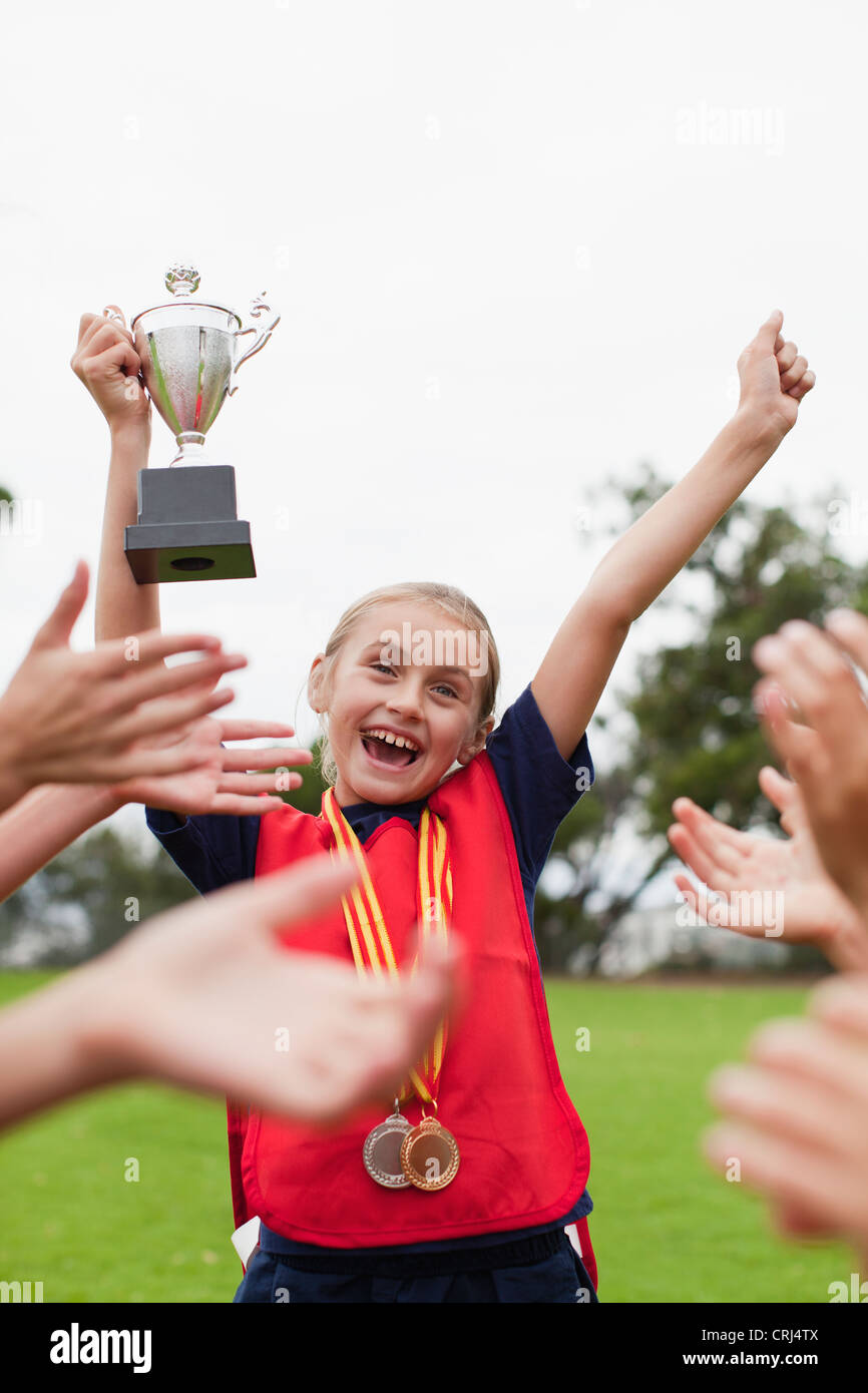 Children cheering teammate with trophy Stock Photo - Alamy