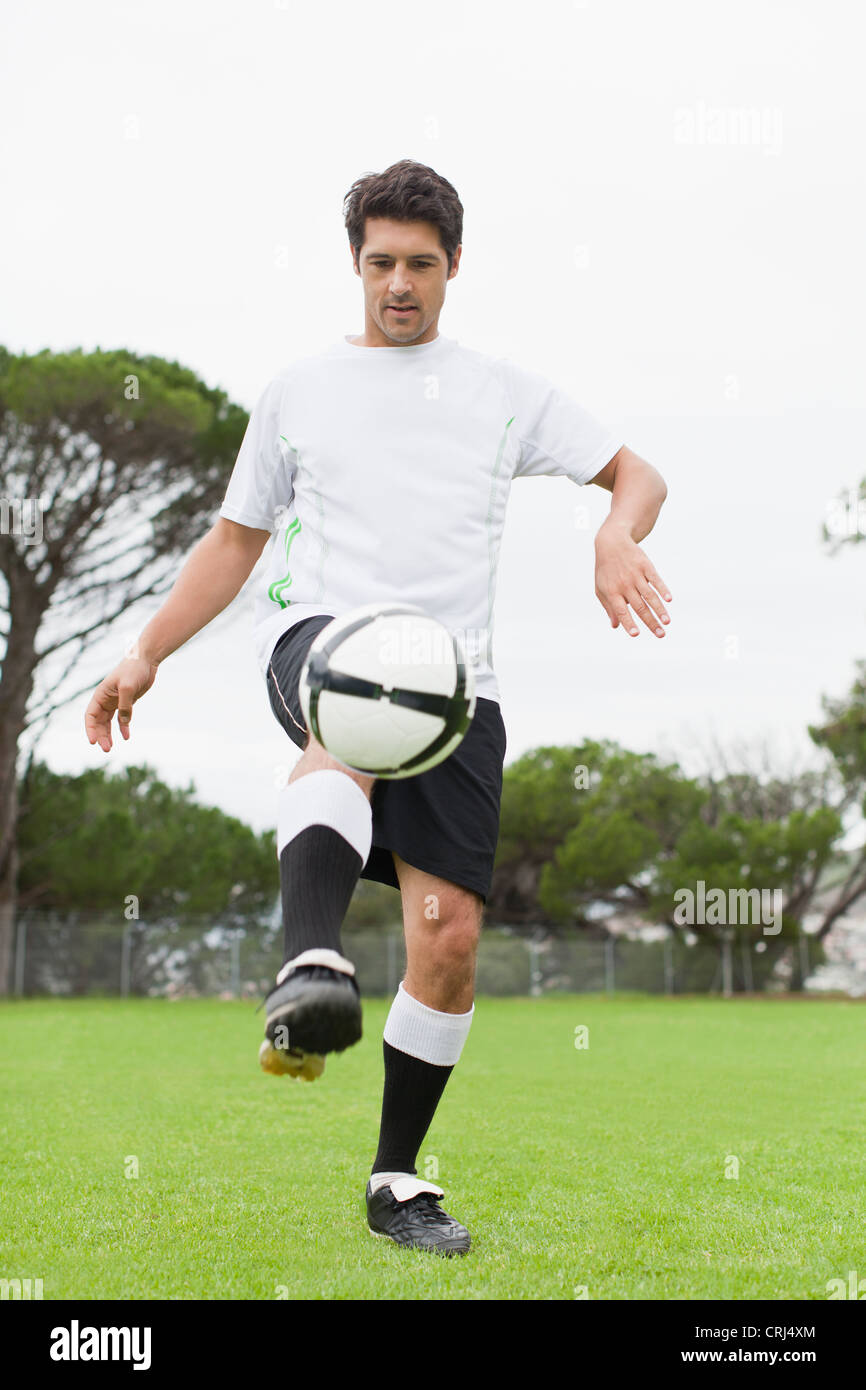 Man playing with soccer ball in field Stock Photo - Alamy
