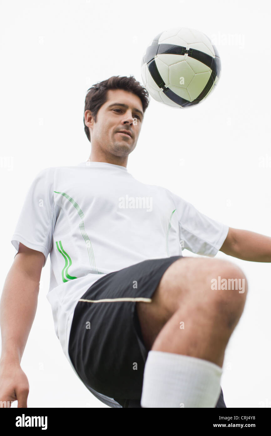 Man playing with soccer ball in field Stock Photo - Alamy