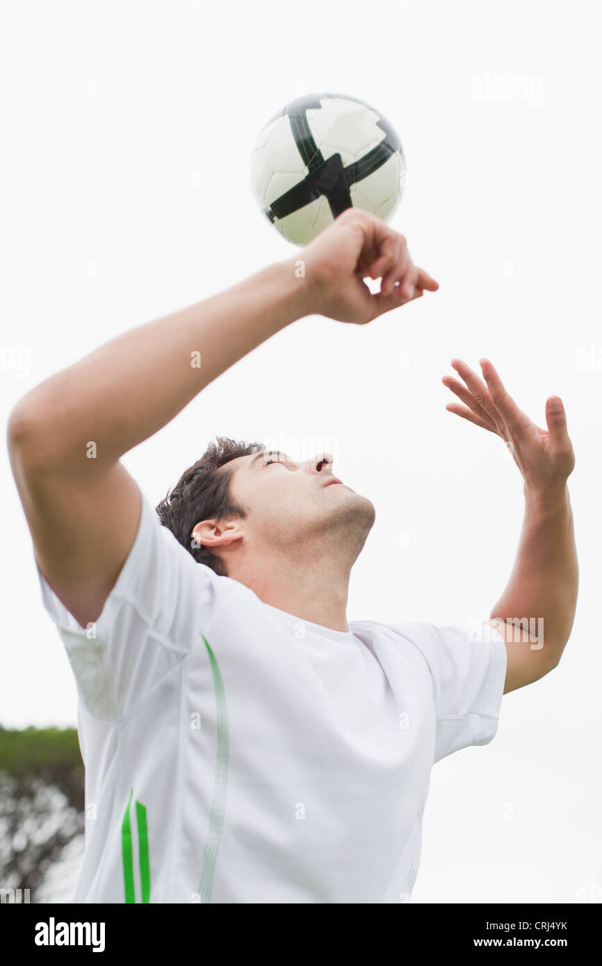 Man playing with soccer ball in field Stock Photo - Alamy