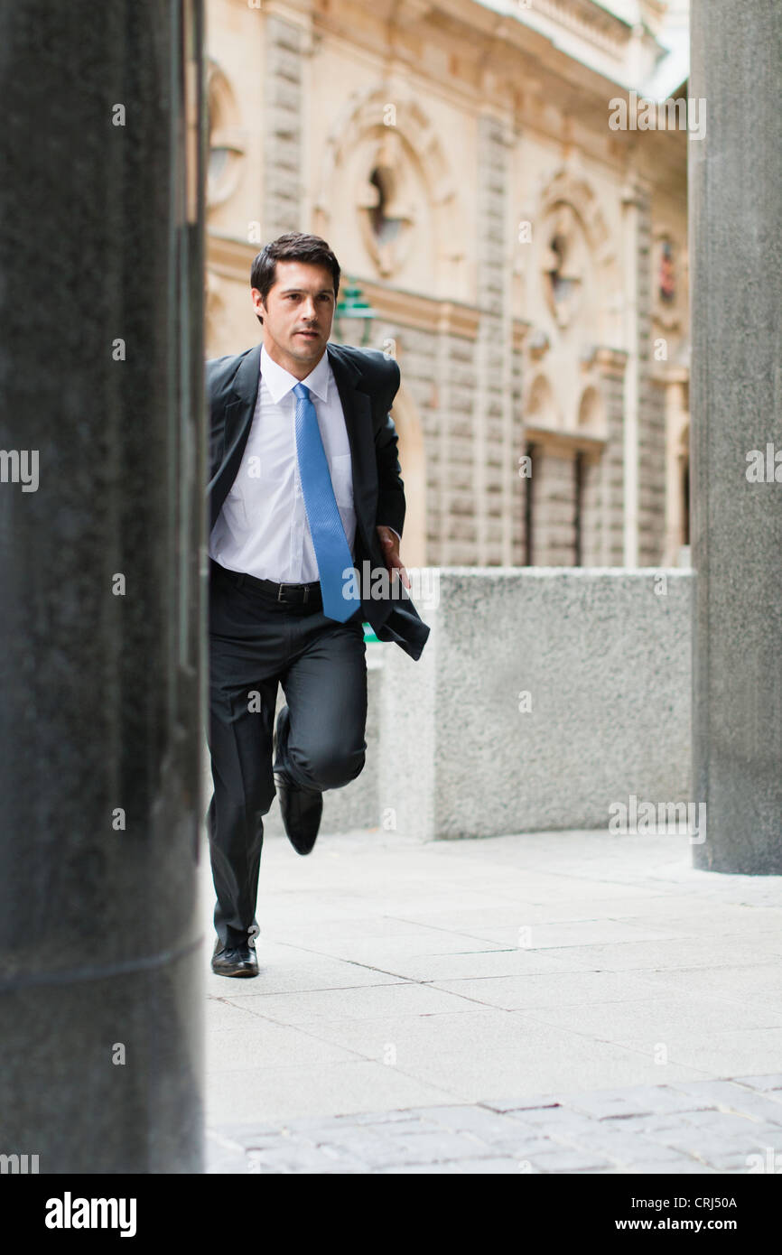 Businessman running on city street Stock Photo - Alamy