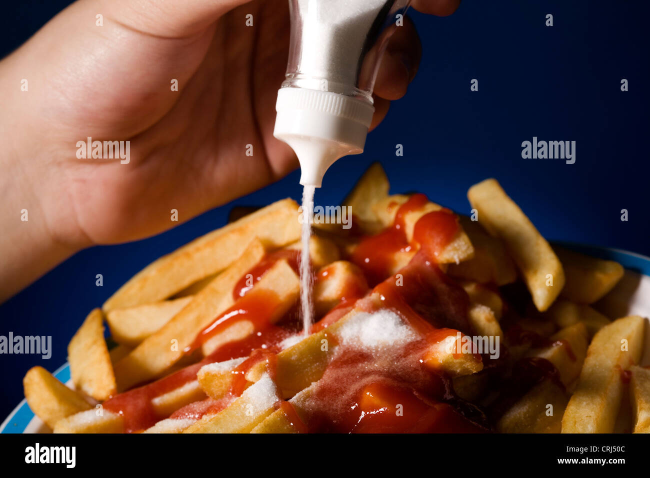 Salt being poured onto a large pile of chips Stock Photo - Alamy