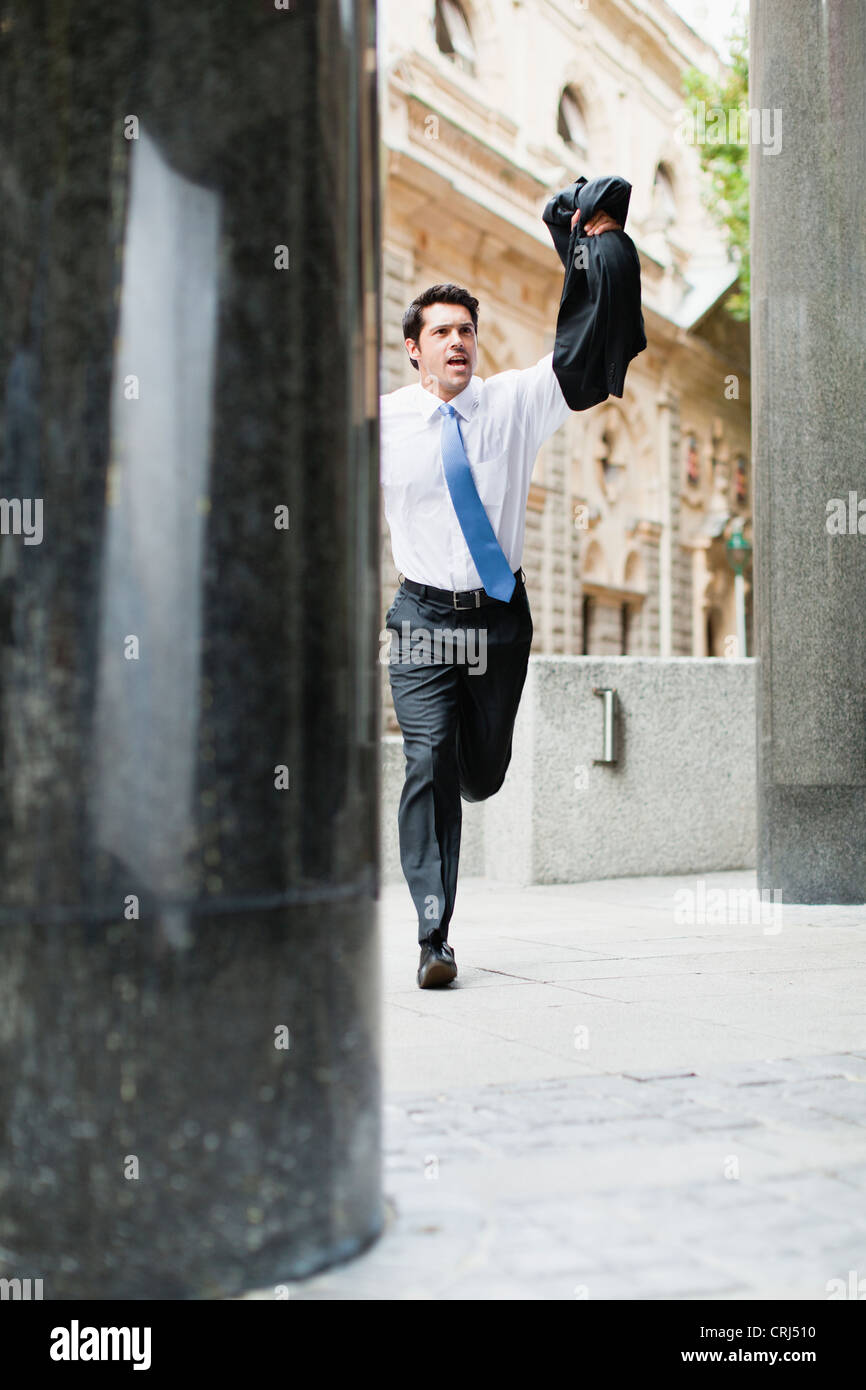 Businessman running on city street Stock Photo - Alamy