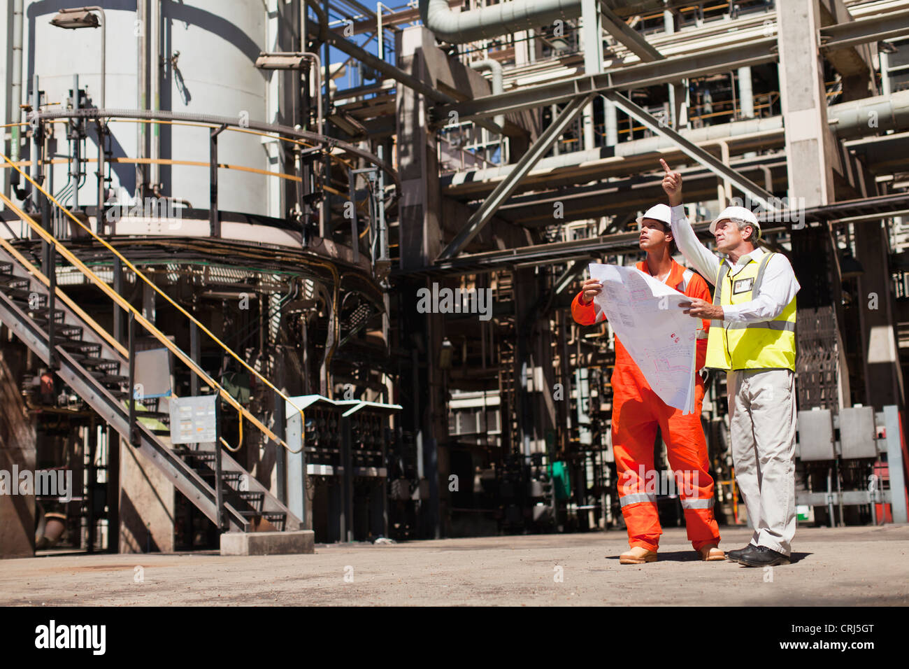 Workers talking at oil refinery Stock Photo - Alamy